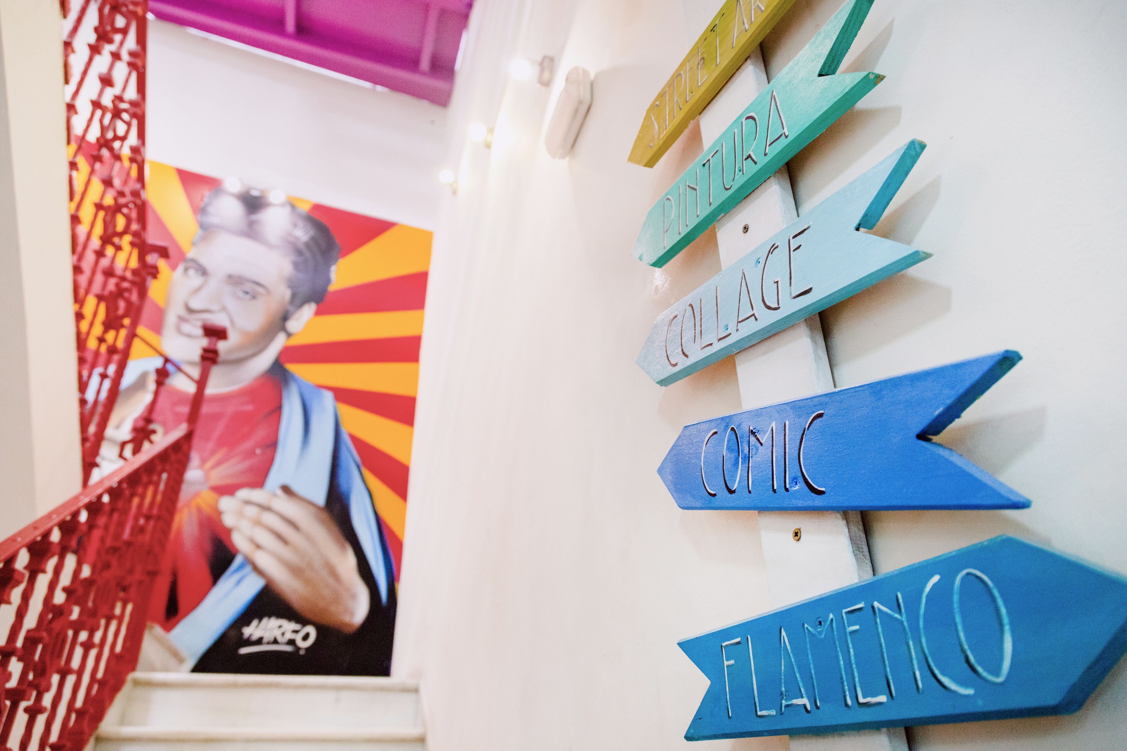 Uma escadaria com um mural colorido e placas de sinalização.
