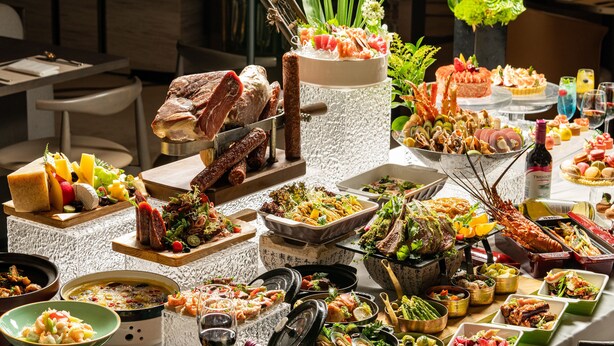 Buffet com diversos pratos, incluindo frutos do mar, carnes e saladas.