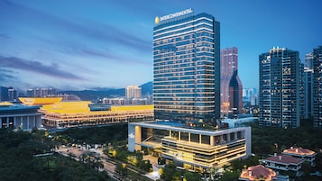 Um hotel moderno com o logotipo InterContinental bem visível, rodeado por edifícios altos e um ambiente urbano iluminado.