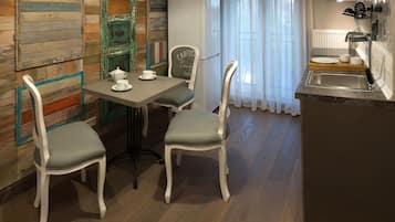 Uma sala de jantar com parede de madeira, uma mesa branca e duas cadeiras.
