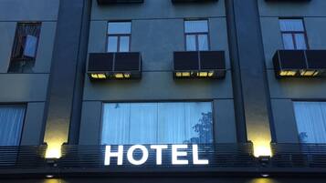 Edifício de hotel com uma placa grande 'HOTEL' sobre a entrada.