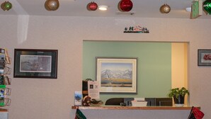 Uma área de recepção com teto de madeira, quadros enquadrados, um balcão e meias de Natal.
