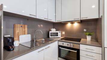 Apartamento, 2 quartos | Cozinha privada | Geladeira, micro-ondas, fogão, cooktop
