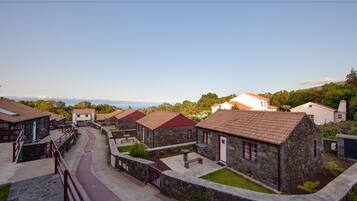 Uma vila costeira com edifícios de pedra, um passeio pavimentado e vista para o mar.