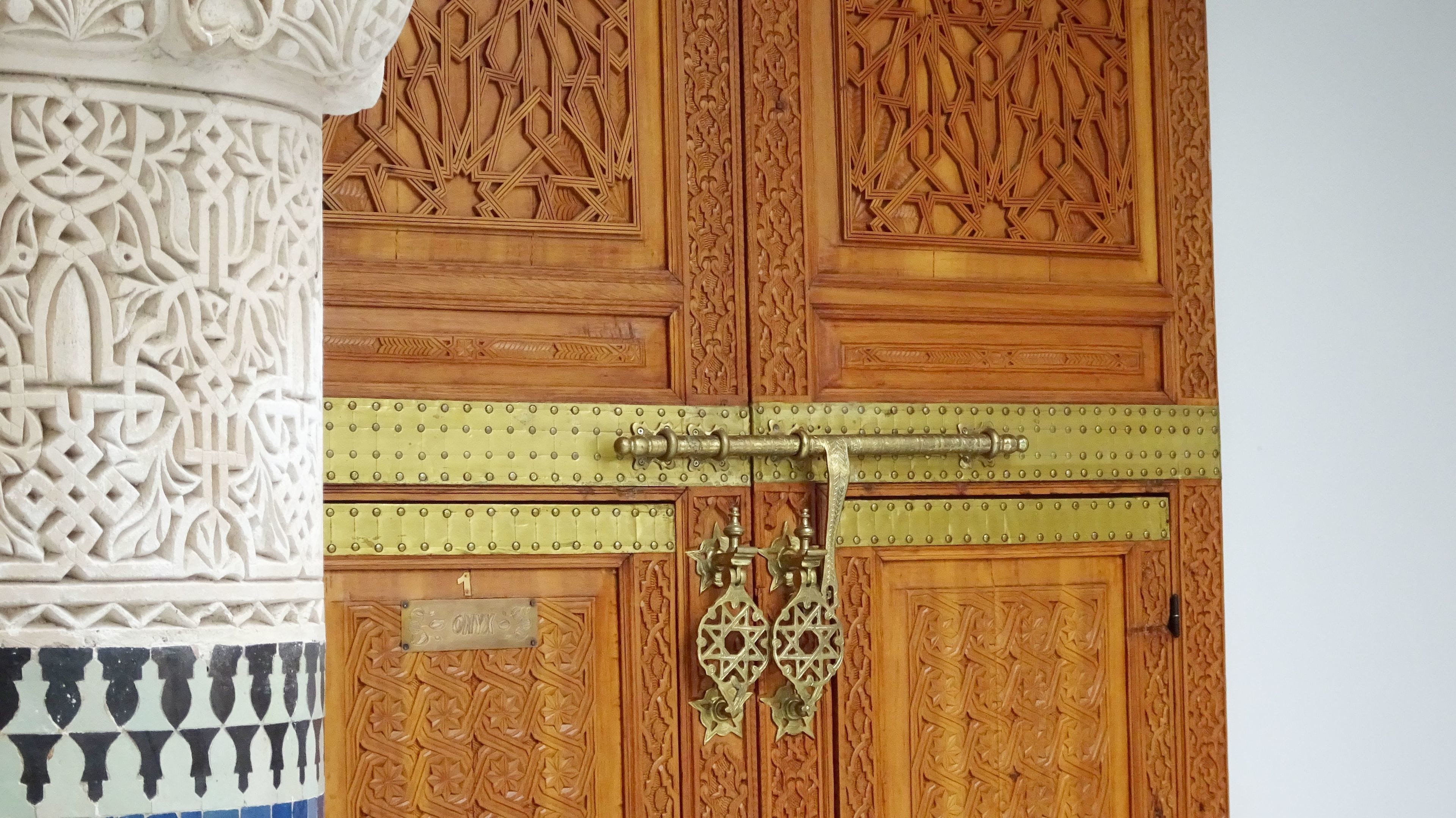 Uma porta de madeira com detalhes entalhados e uma fechadura de metal.
