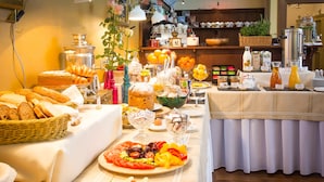 Buffet com diversos alimentos, incluindo pão, queijo e frutas.
