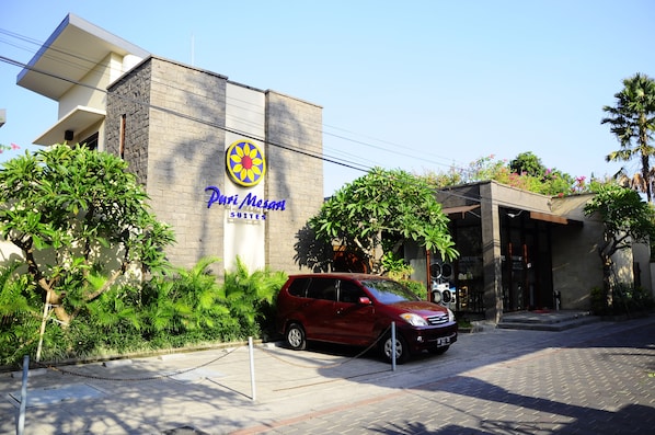 Um edifício com uma placa que diz 'Puri Mesani Suites'.