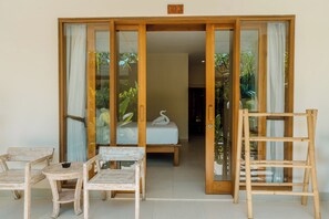 Um quarto com uma cama, uma mesa, duas cadeiras e uma escada de madeira.