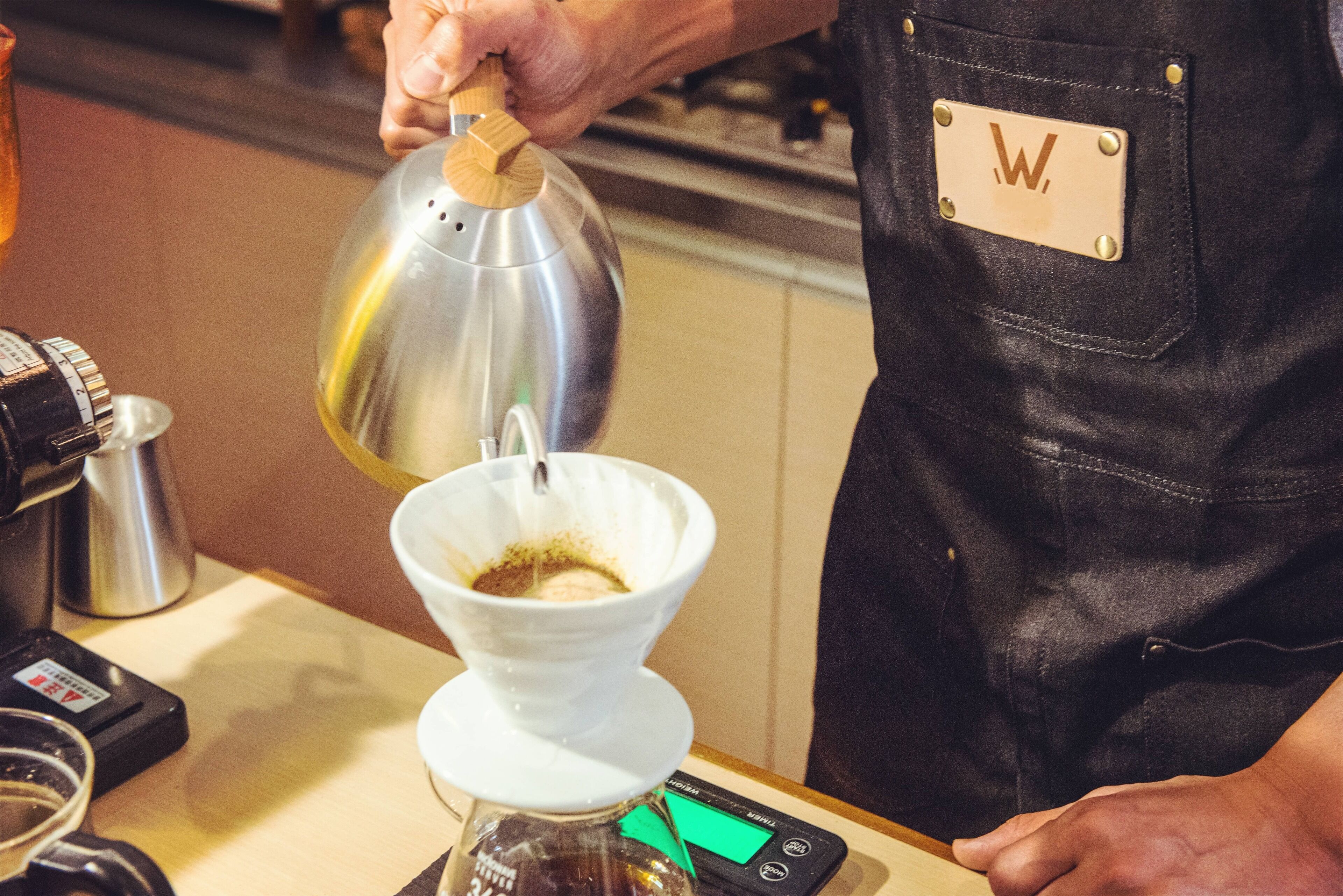 Alguém está a servir café numa cafeteira branca.