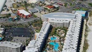 Resort com vários edifícios altos, um amplo estacionamento e uma área de piscina central com diversas piscinas.