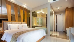 Quarto moderno com uma cama grande, box de vidro e closet espaçoso.