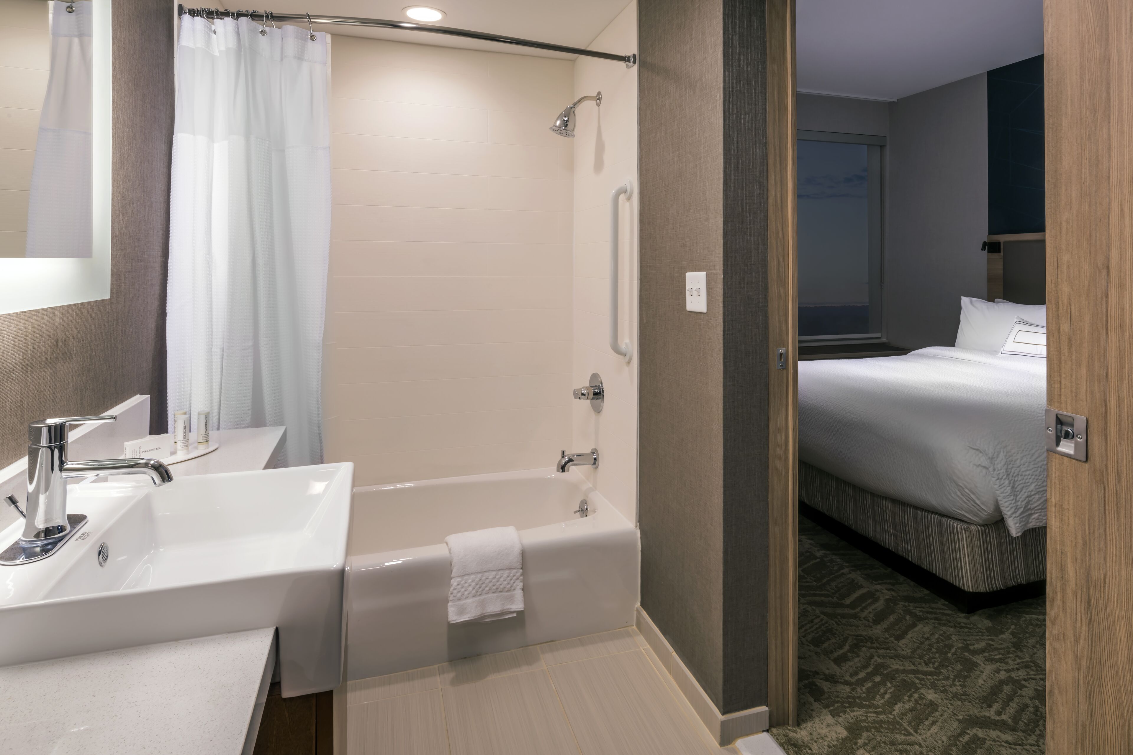 Um banheiro de hotel moderno com banheira, pia e chuveiro.