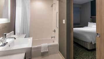 Um banheiro de hotel moderno com banheira, pia e chuveiro.