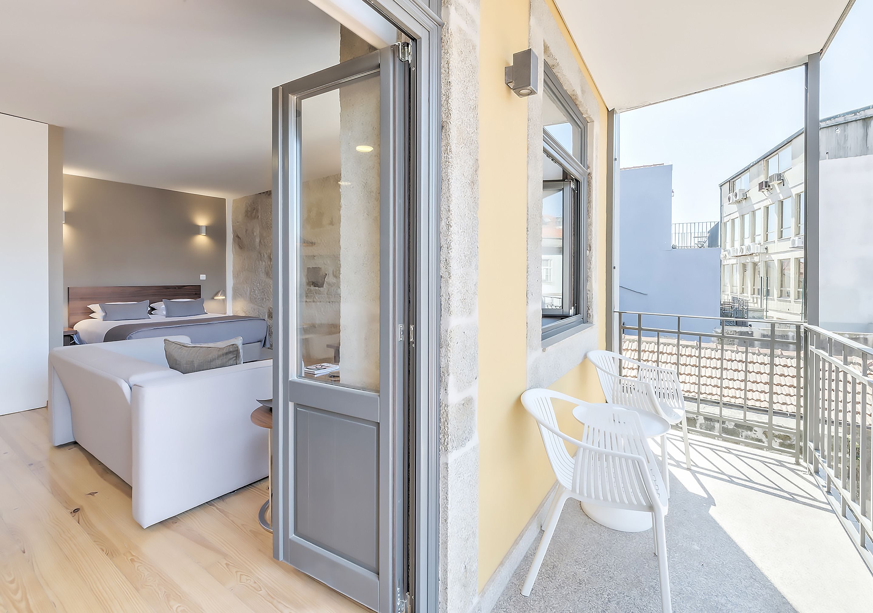 Um apartamento moderno com varanda, um sofá e uma sala de jantar.