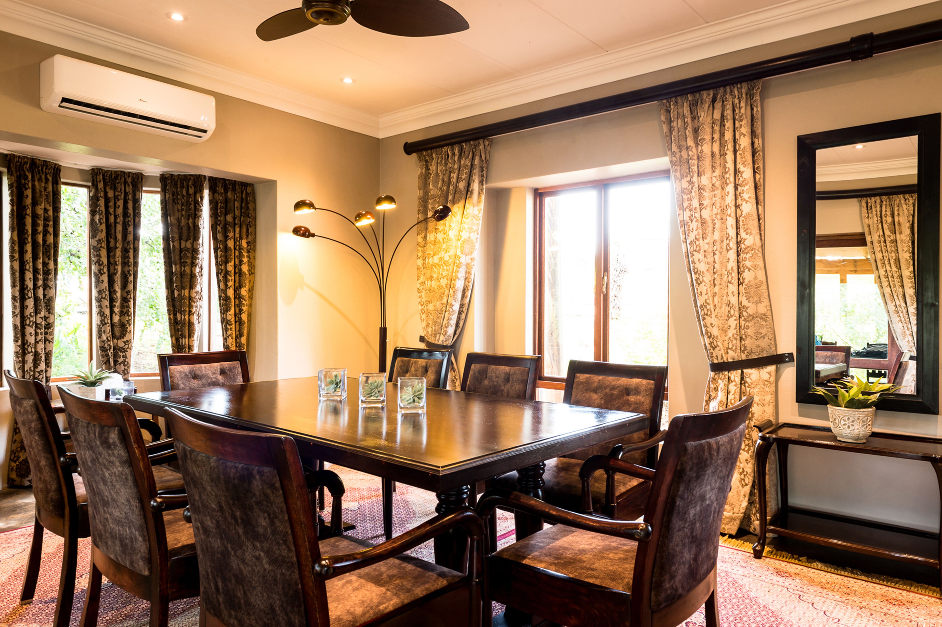 Sala de conferências com uma mesa grande, seis cadeiras e um ventilador de teto.