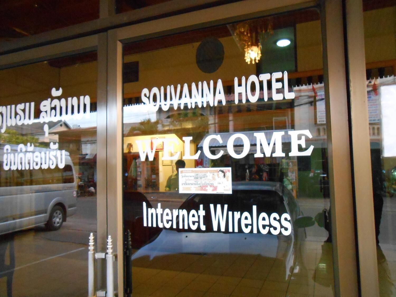 Entrada de hotel com um letreiro de 'Welcome' e aviso de 'Internet Wireless'.