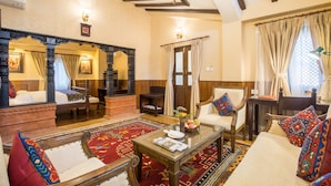 Quarto tradicional com cama, sofá, mesa de centro e espelho.