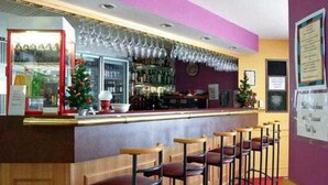 Uma área de bar com balcão, vários bancos e um enfeite de árvore de Natal.