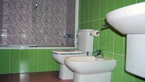 Casa de banho com sanita, bidé e lavatório.