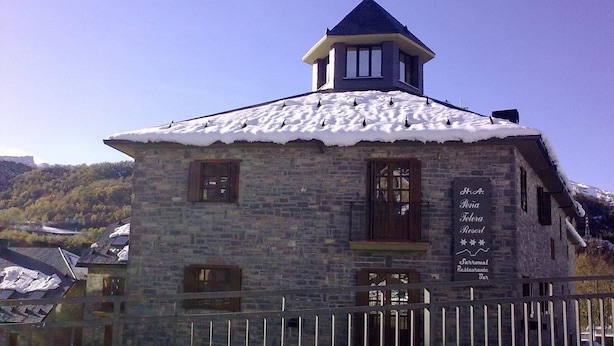 Um edifício de pedra com uma placa que indica ser restaurante e bar.