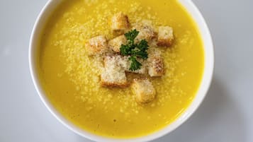 Uma tigela de sopa com croutons e salsa.