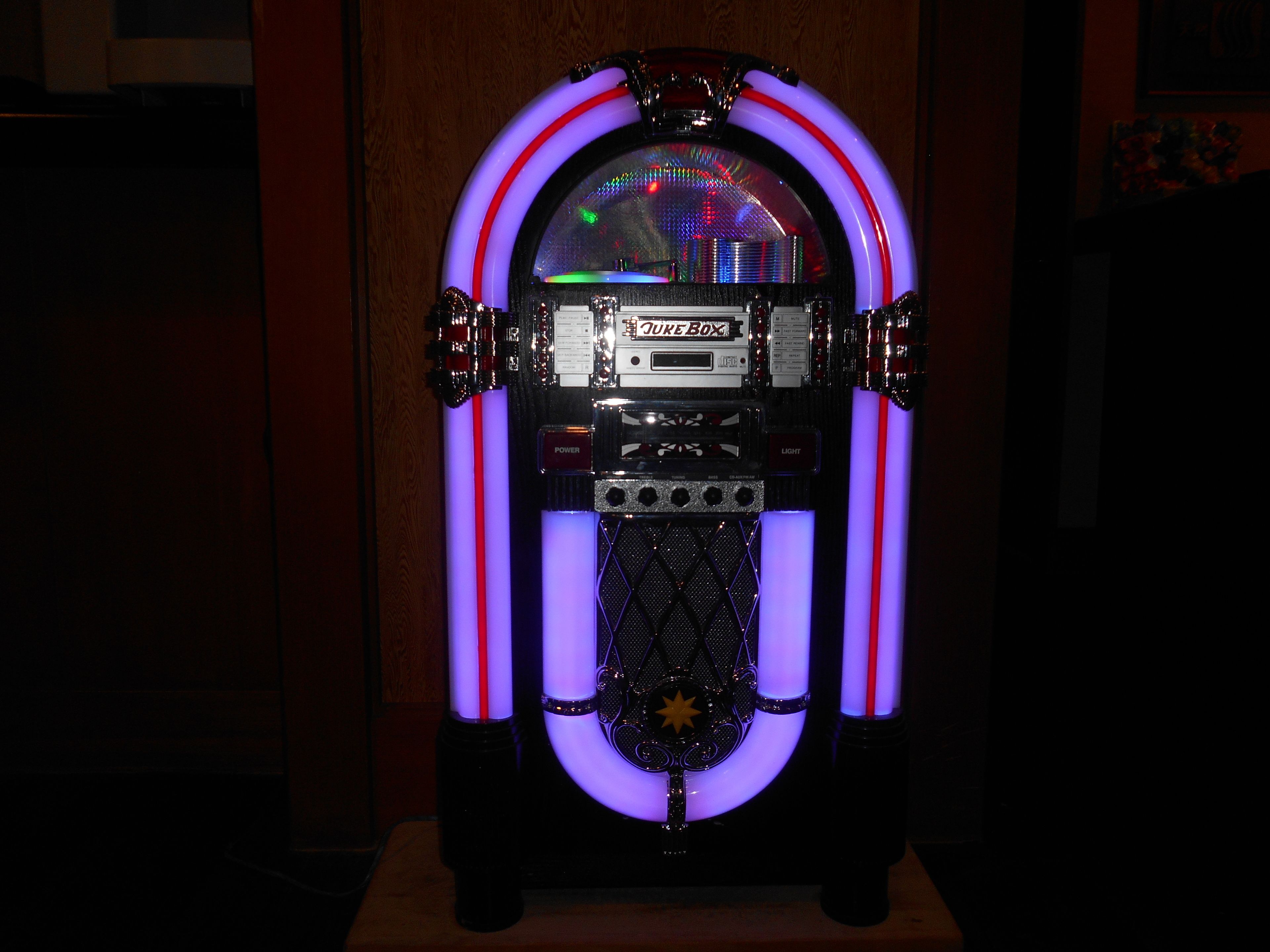 Um jukebox com luzes de neon iluminadas e uma decoração em forma de estrela no topo.