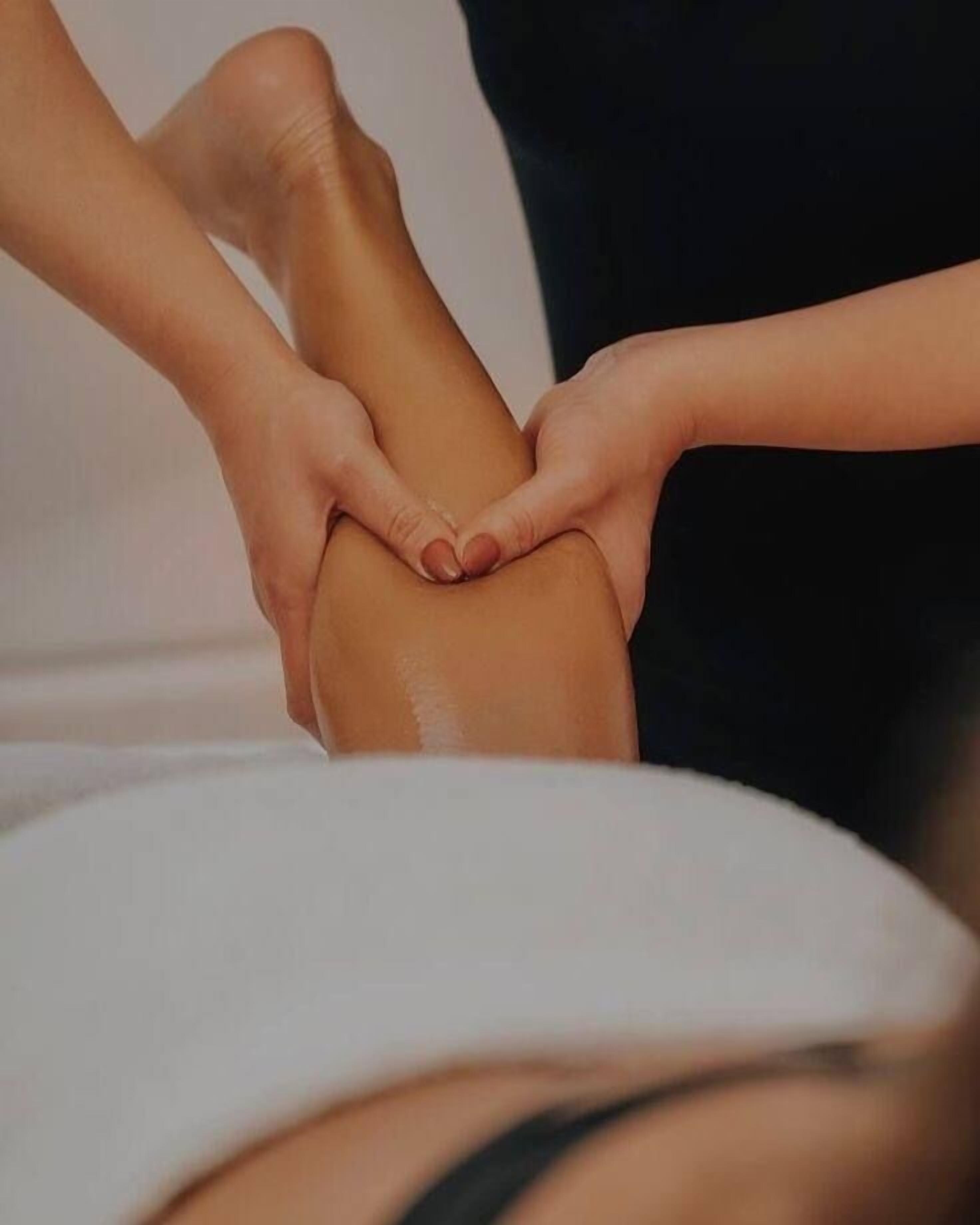 Uma pessoa recebendo massagem nas pernas.