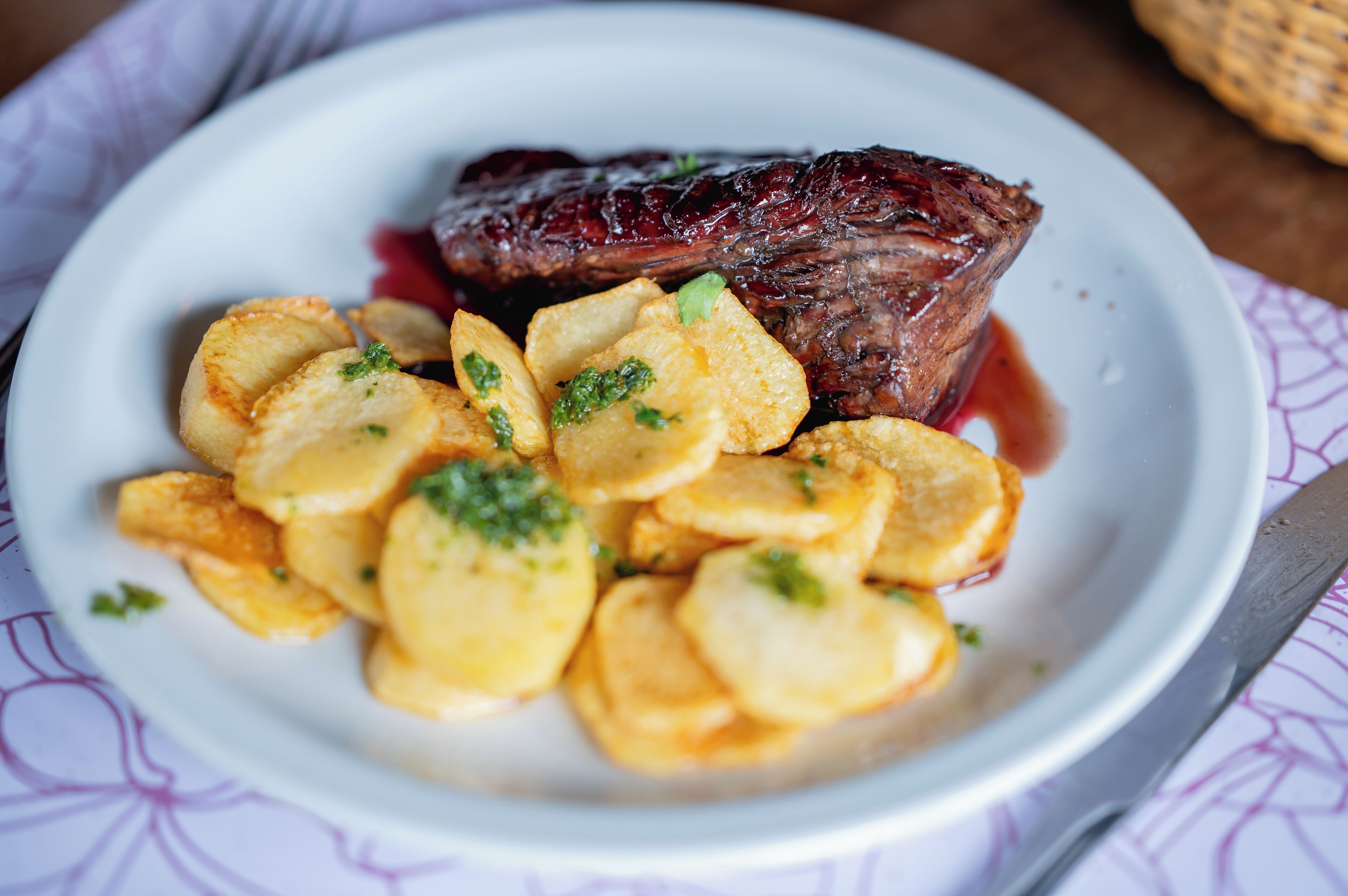 Um prato com bife e rodelas de batata.