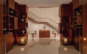 Um interior moderno com escada de madeira, prateleiras embutidas e iluminação decorativa.