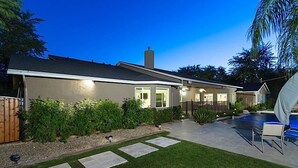 Uma casa moderna com gramado bem cuidado, área de varanda e piscina.