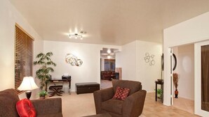 Sala de estar com dois sofás, uma mesa de centro, uma luminária e arte decorativa nas paredes.
