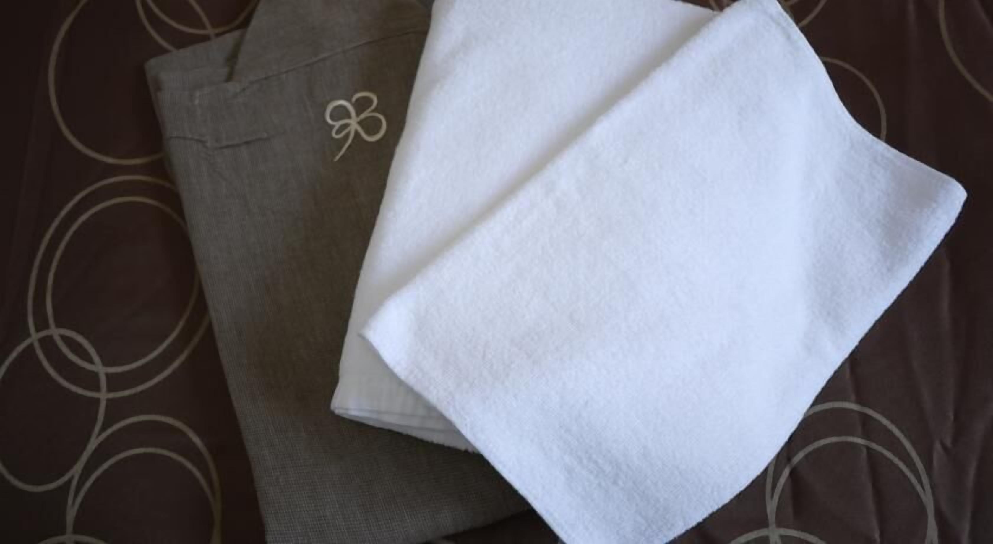 Uma cama com um edredom marrom estampado e um travesseiro branco.