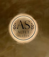 Placa circular com o texto 'AS ALLET SUITES', indicando o nome de um hotel ou alojamento.