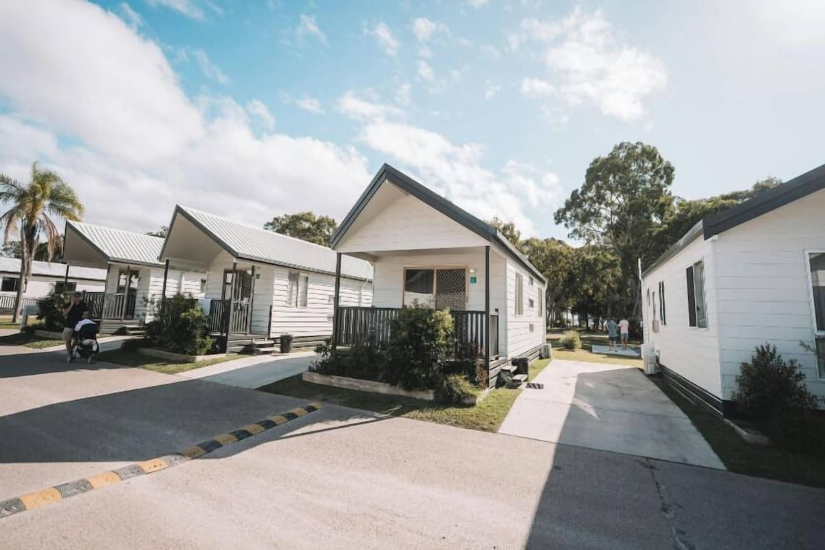 Uma fileira de casas móveis com um caminho de entrada pavimentado e uma pequena área gramada na frente.