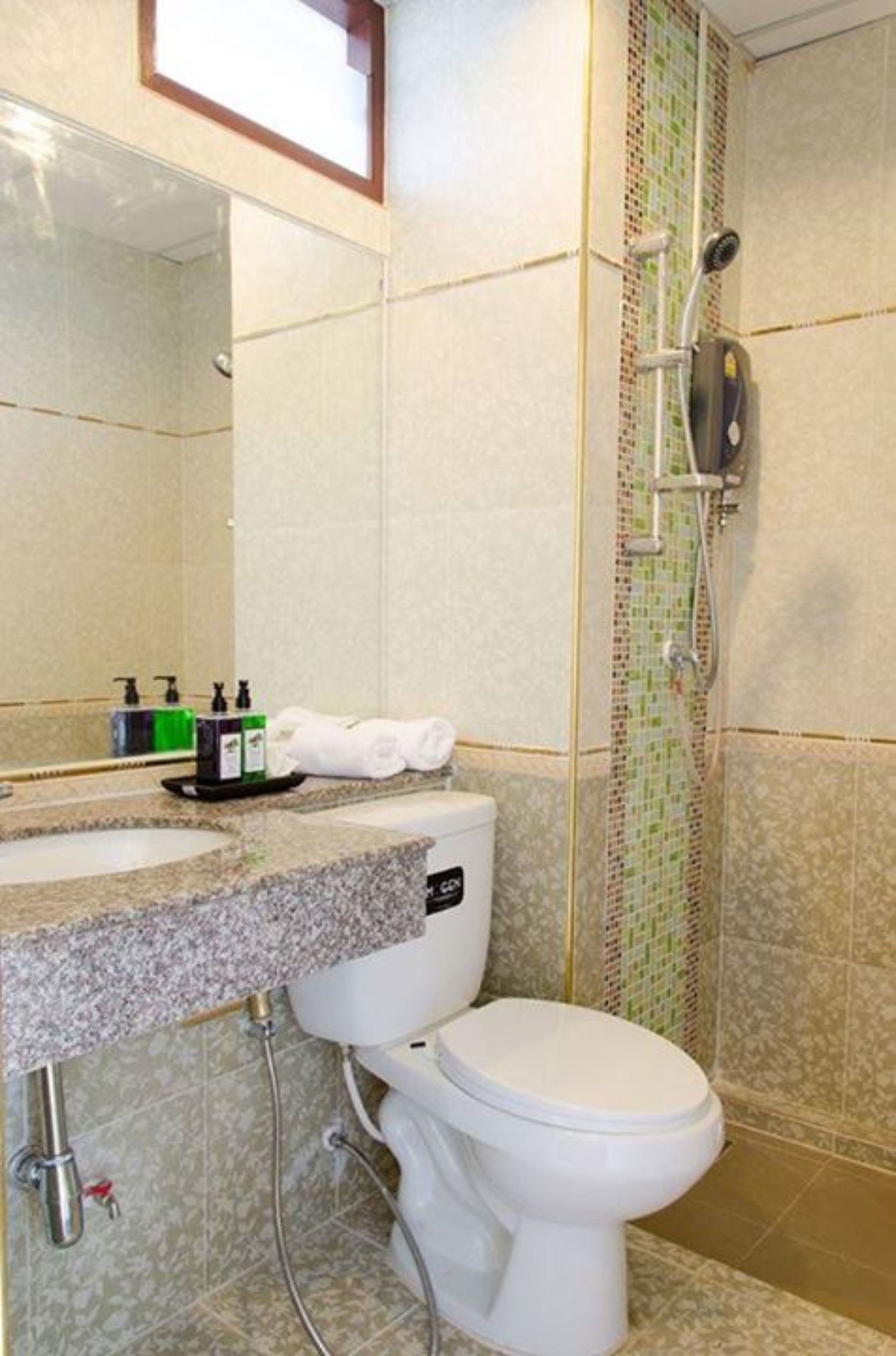 Casa de banho com sanita, lavatório e chuveiro.