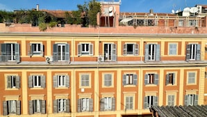 Um edifício com várias andares, venezianas e sacadas uniformes.
