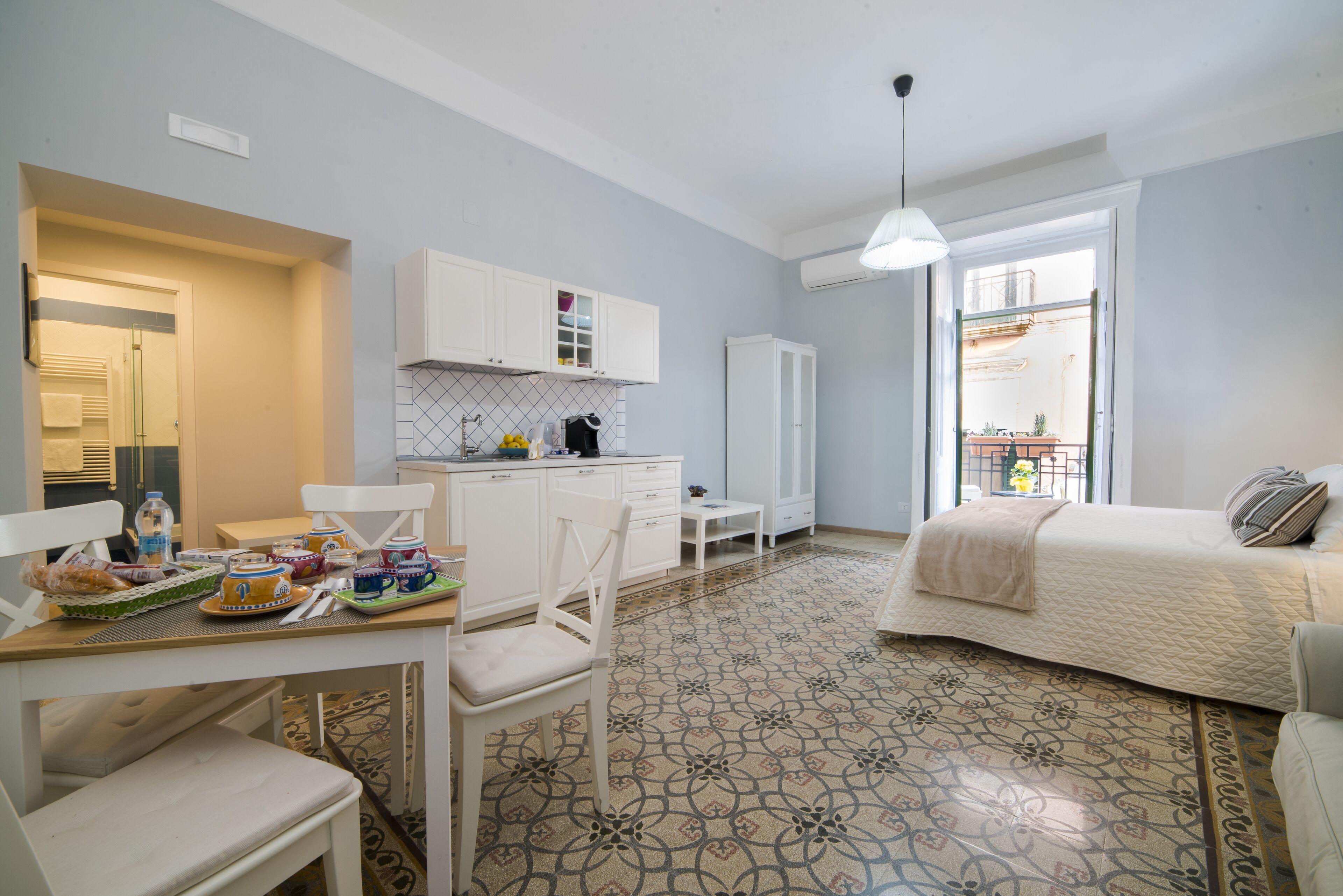 Quarto compacto com cozinha compacta, área de refeições e cama.