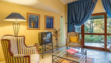 Suite Familiar, 2 camas queen-size, casa de banho privativa, vista para o jardim | Sala de estar | Televisor