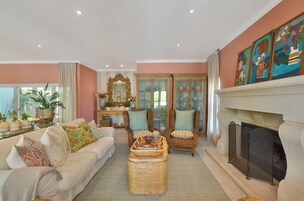 Sala de estar com lareira, sofá, mesa de centro e espelho decorativo.