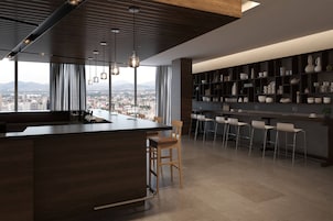 Uma cozinha moderna com uma ilha grande, bancada para refeições e vista para a cidade.