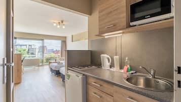 Executive Studio Twin with daily cleaning | Kitchenette privada | Um frigorífico, um micro-ondas, uma placa de cozinha