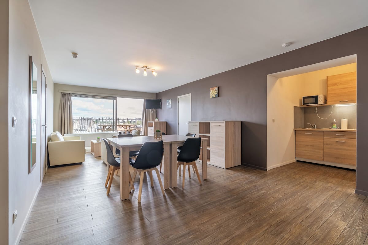 Apartamento moderno com área de refeições, cozinha e varanda com vista.