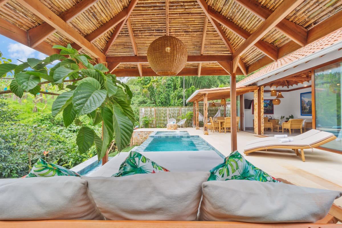 Uma área de piscina com espreguiçadeiras e um espaço de estar coberto.