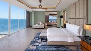 Quarto espaçoso com cama grande, ventoinha no teto e vista para o oceano.