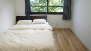 Quarto com uma cama, janela e tomada na parede.