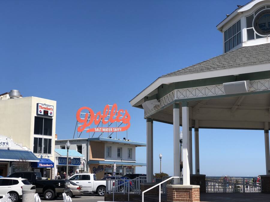 Uma cidade costeira com uma placa de destaque para 'Gollie's Salt Water Taffy'.