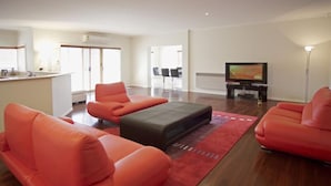 Uma sala de estar moderna com um sofá, uma mesa de centro e uma TV de tela plana.
