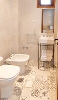 Casa de banho com sanita, bidé e lavatório.