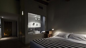 Um quarto moderno com uma cama grande, uma toucador embutido com espelho e um abajur.