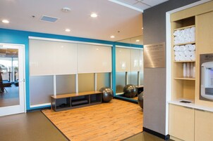 Centro de fitness com bolas de exercício, um banco e um ponto de hidratação.